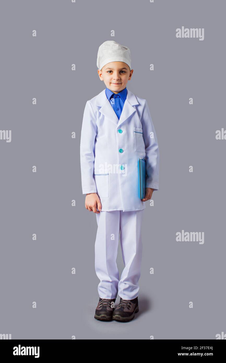 Boy in doctor uniform isolated on grey background Stock Photo - Alamy