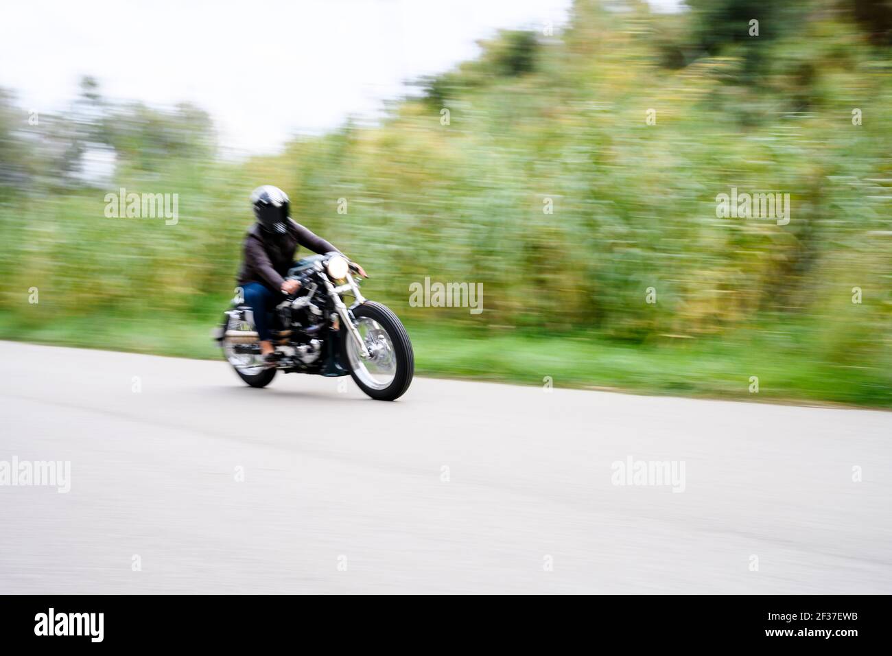 Side view of a blurred vintage motorbike on country road Stock Photo ...