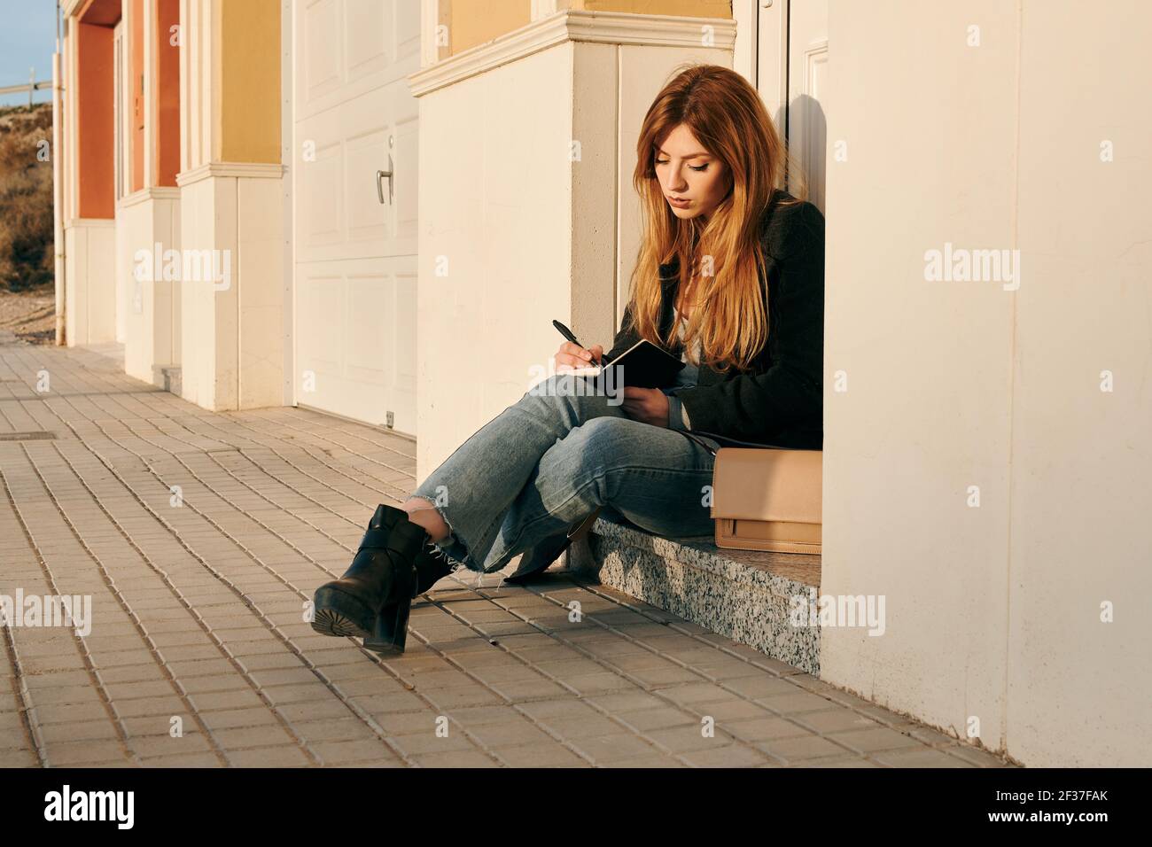 Woman writes in notebook sitting hi-res stock photography and images ...