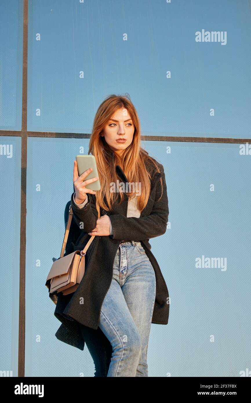 Young businesswoman is leaning against the windows of a building Stock ...