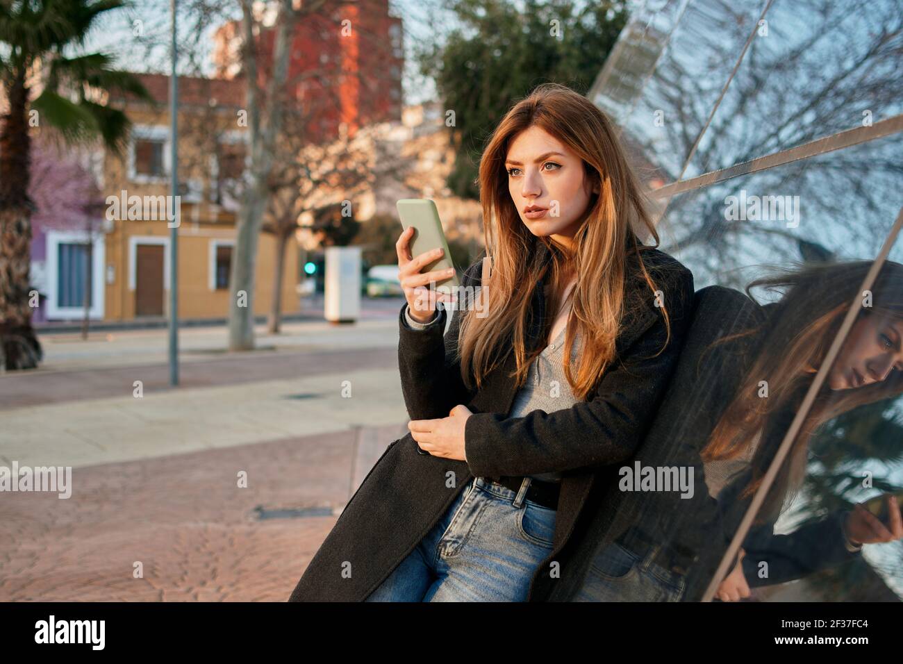 Young businesswoman is leaning against the windows of a building Stock ...