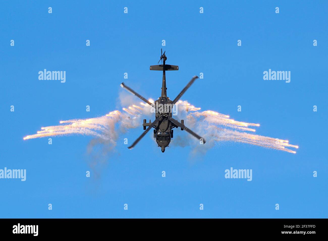 Military Helicopter Shooting Flares into Blue Sky Stock Photo - Alamy