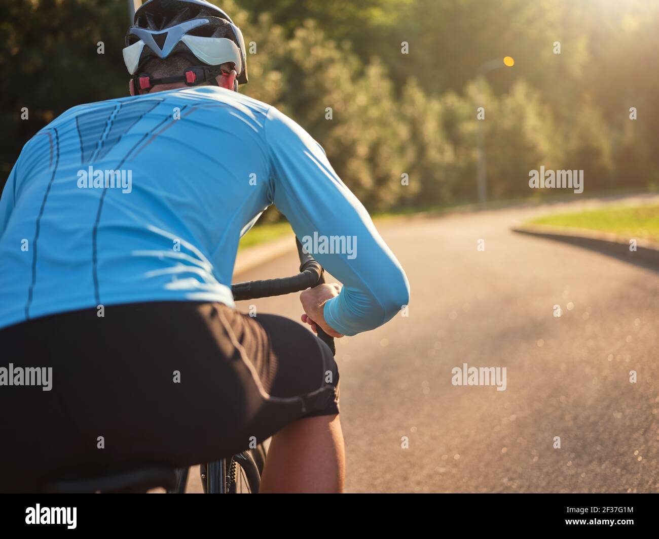 Rear view of professional male cyclist on the road. Biker wearing ...