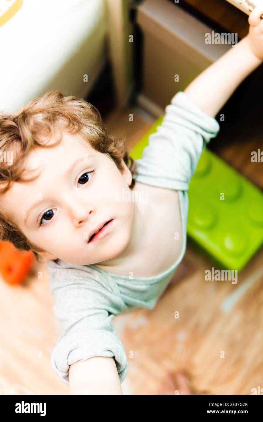 two year old boy looking up asking to be caught Stock Photo - Alamy