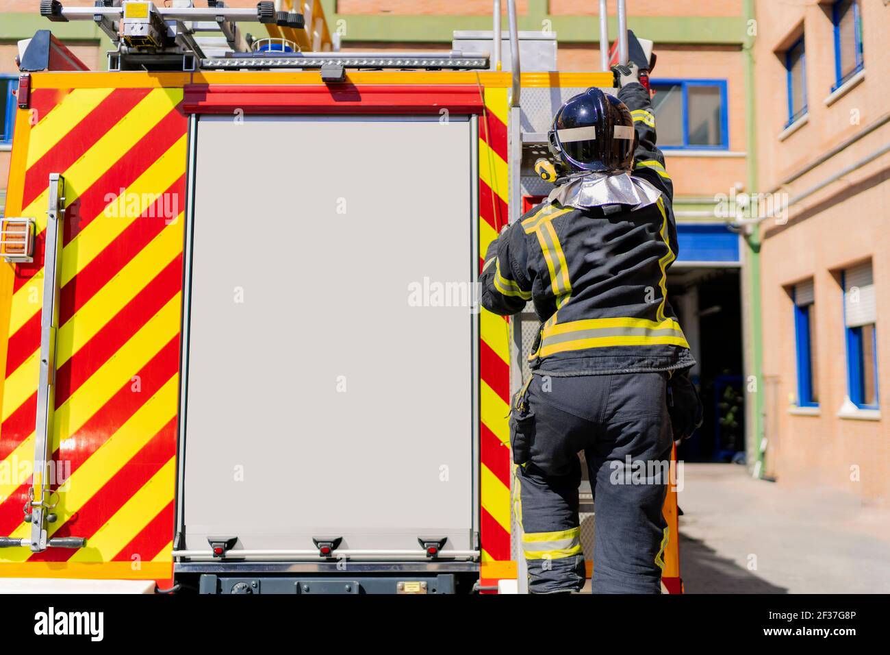 firefighter getting on the truck to work in emergency Stock Photo - Alamy