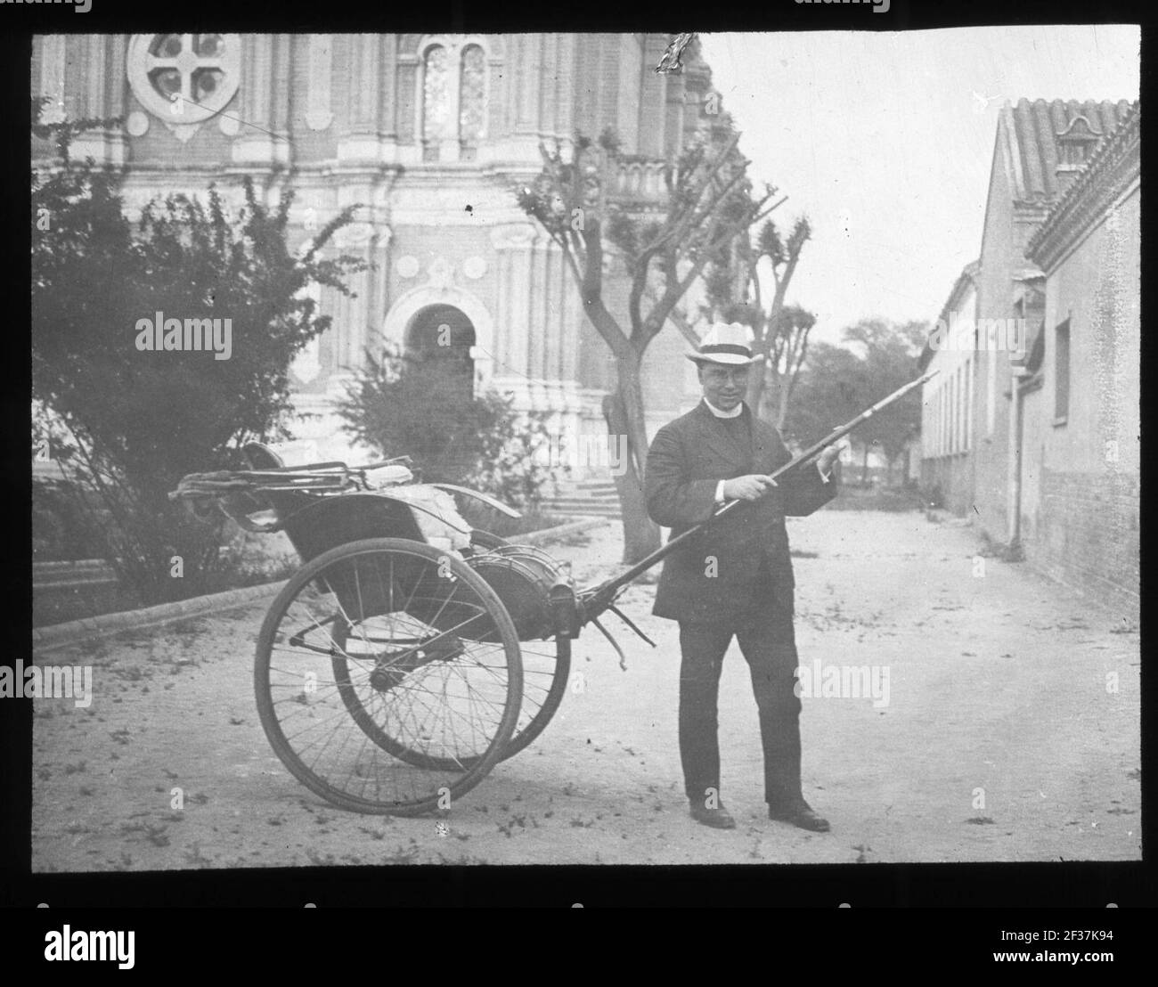 Priest standing with a rickshaw near a church, China, ca. 1918-1938 ...