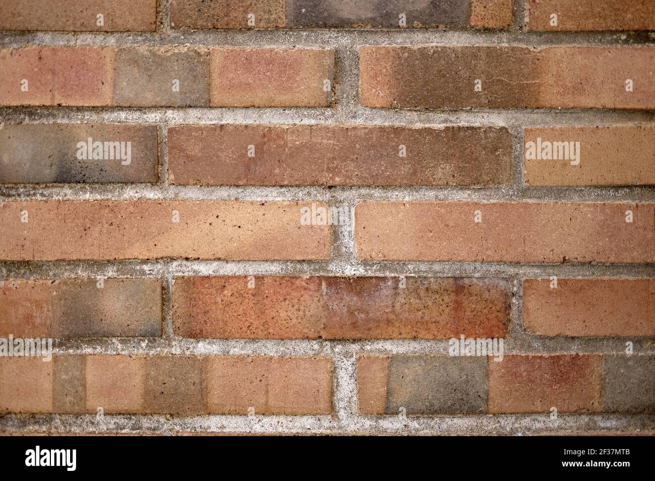 detail of a wall of light and dark brown bricks joined with mortar ...