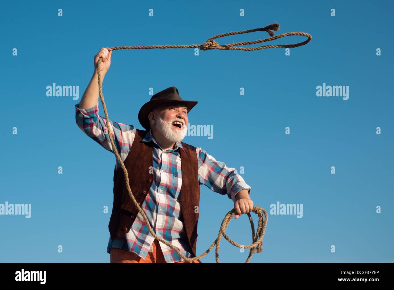 Old wild west cowboy with rope. Bearded western man throwing lasso with ...