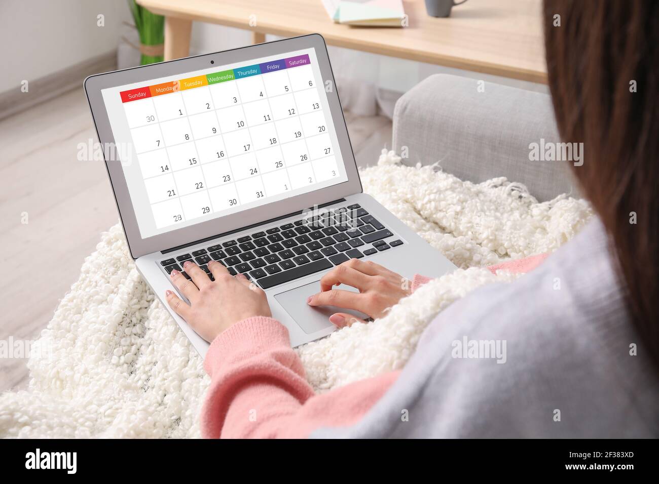Woman with laptop using calendar application at home Stock Photo - Alamy