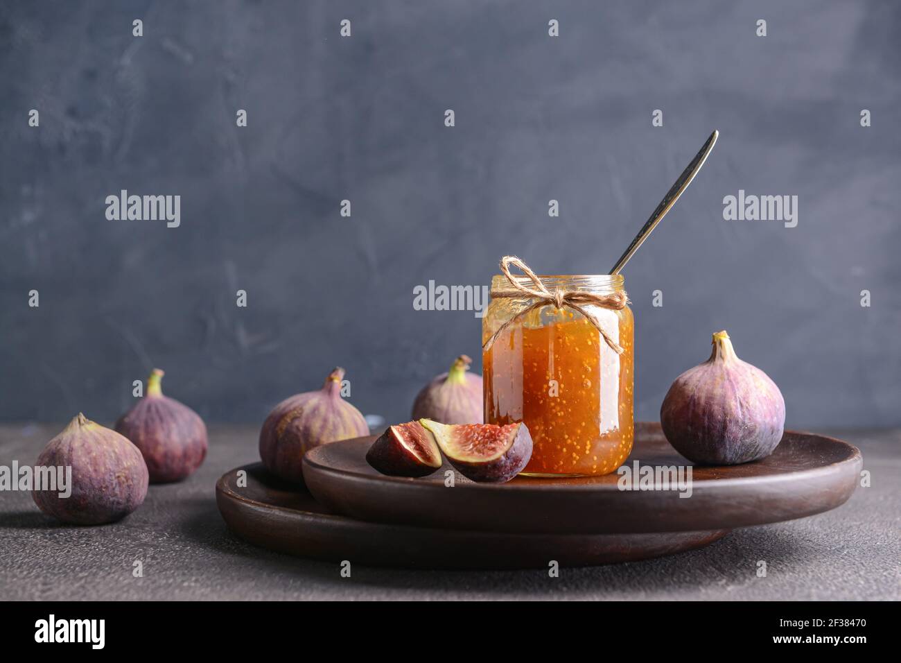 Composition with sweet fig jam on dark background Stock Photo - Alamy