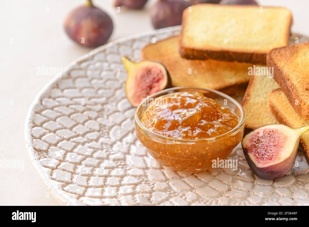 Composition with sweet fig jam on light background Stock Photo - Alamy