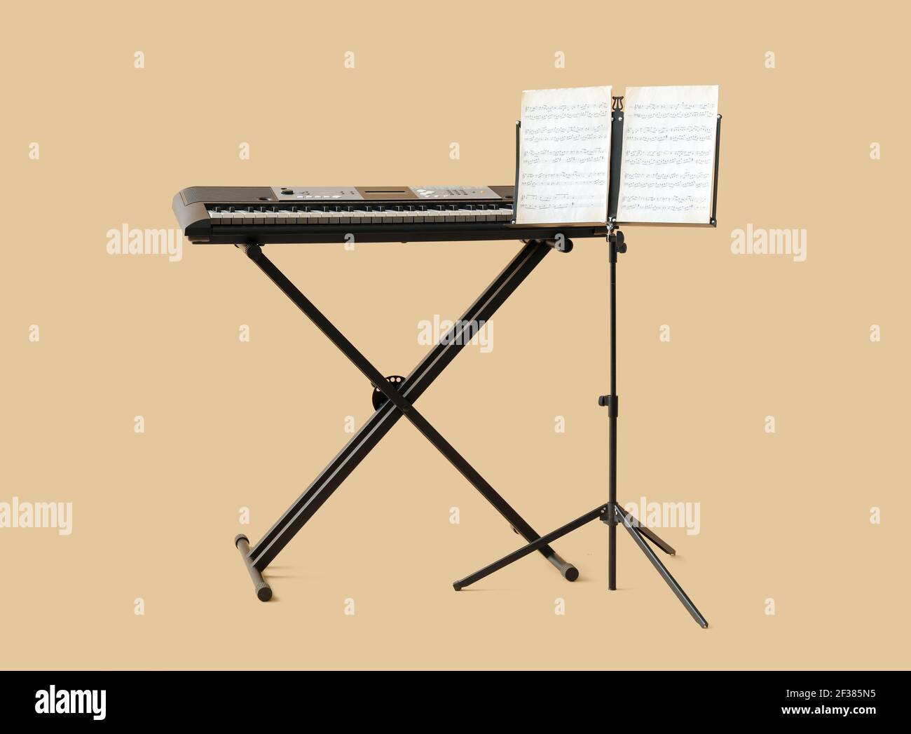 Note stand with music sheets and synthesizer on color background Stock ...