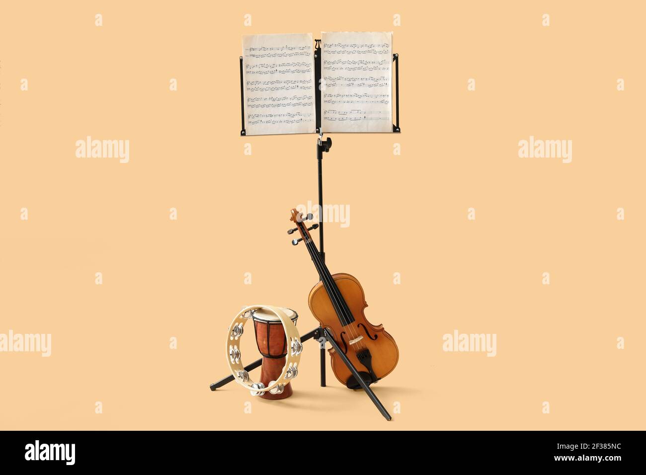 Note stand with music sheets and different musical instruments on color ...
