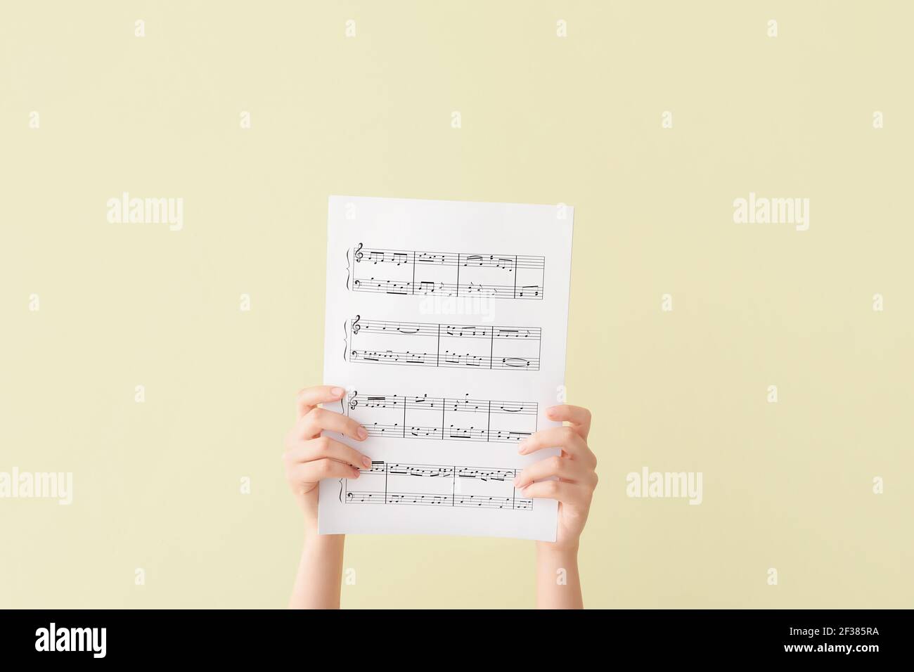 Woman holding music notes on color background Stock Photo - Alamy