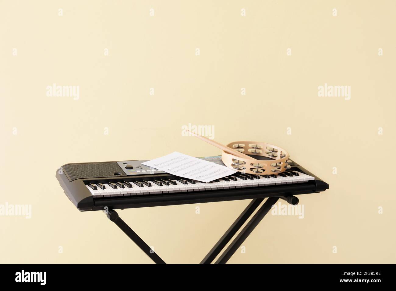 Synthesizer, tambourine, drumsticks and music notes on color background ...