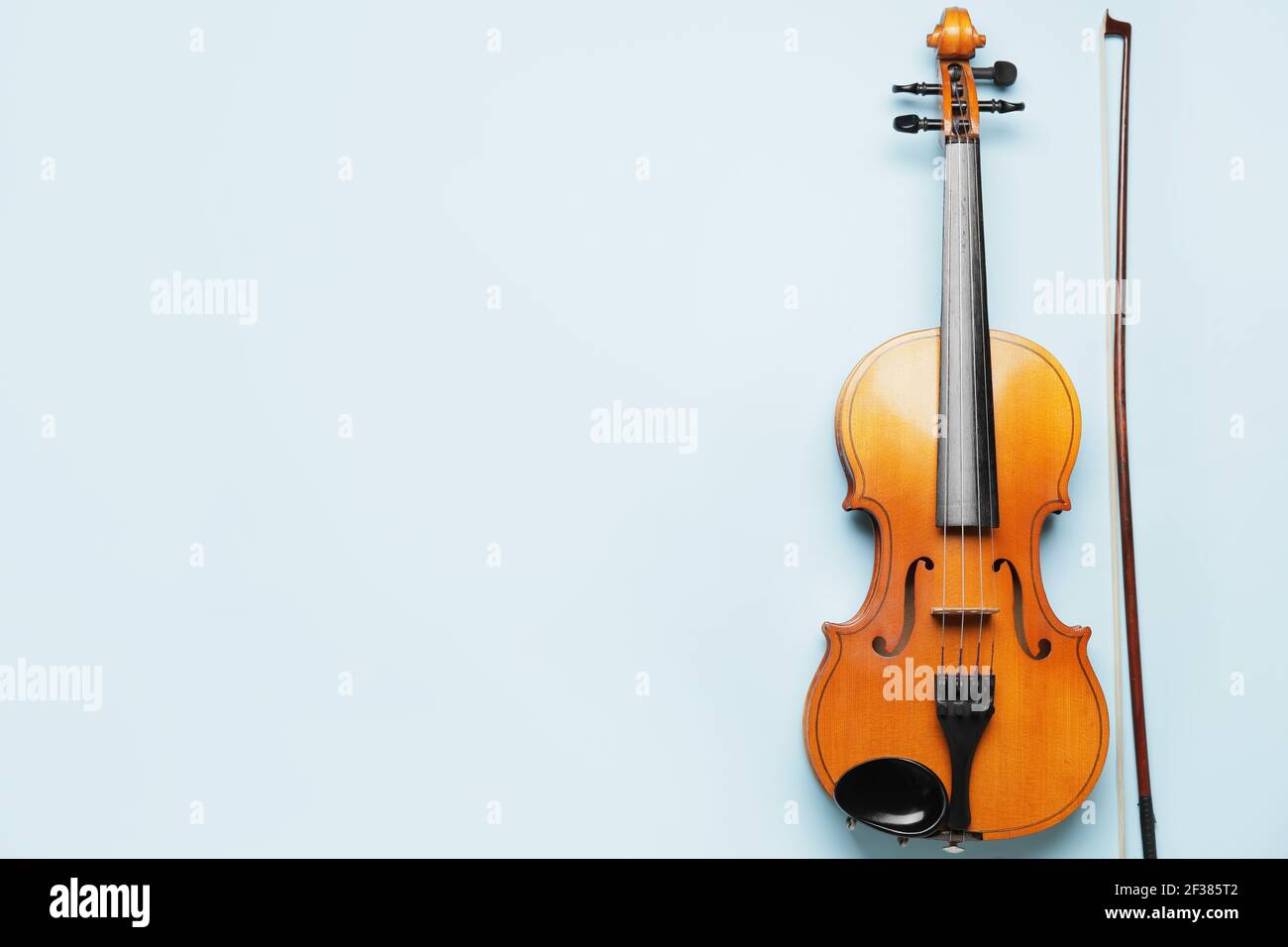Beautiful violin and bow on color background Stock Photo - Alamy