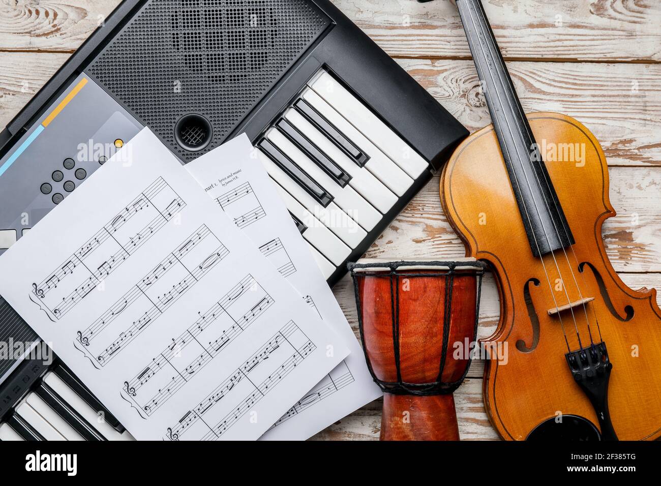 Different musical instruments and music notes on light wooden ...