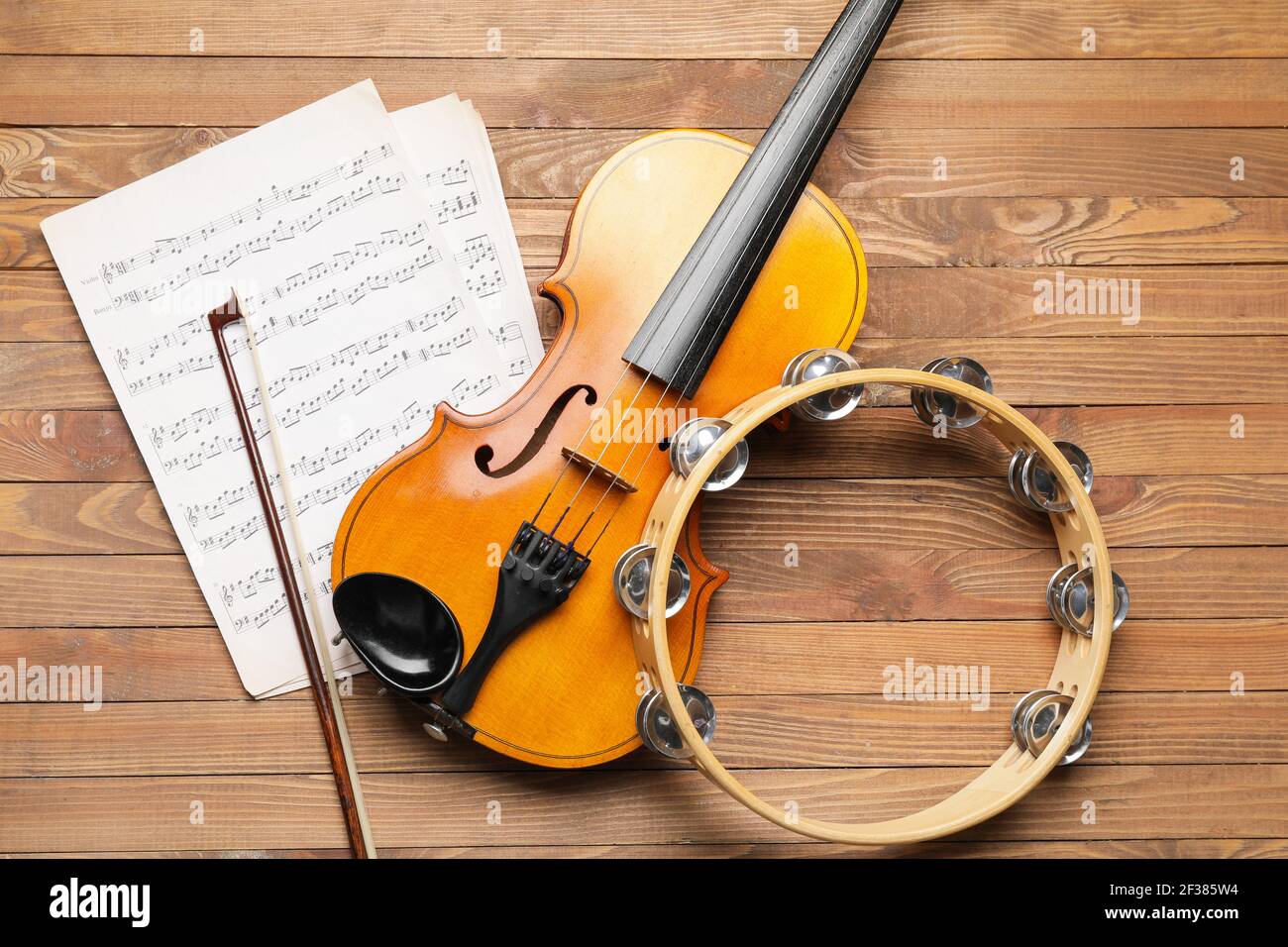 Violin, tambourine and music notes on wooden background Stock Photo - Alamy