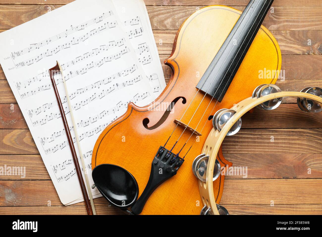 Violin, tambourine and music notes on wooden background Stock Photo - Alamy