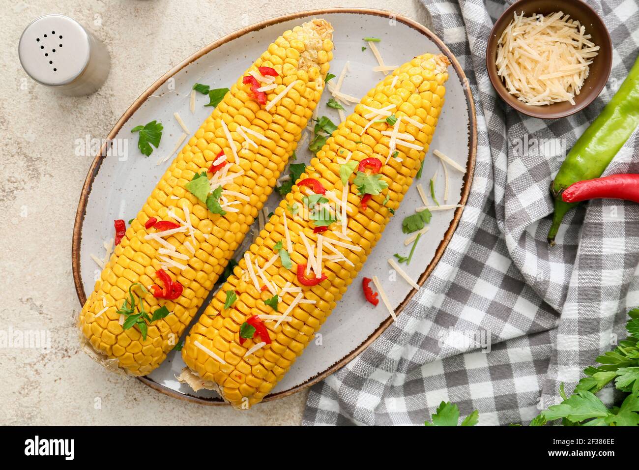 Plate with tasty baked corn cobs on light background Stock Photo - Alamy