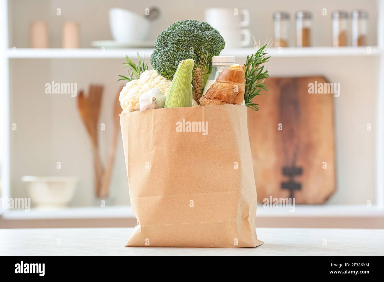 Paper bag with different products on table in kitchen Stock Photo - Alamy