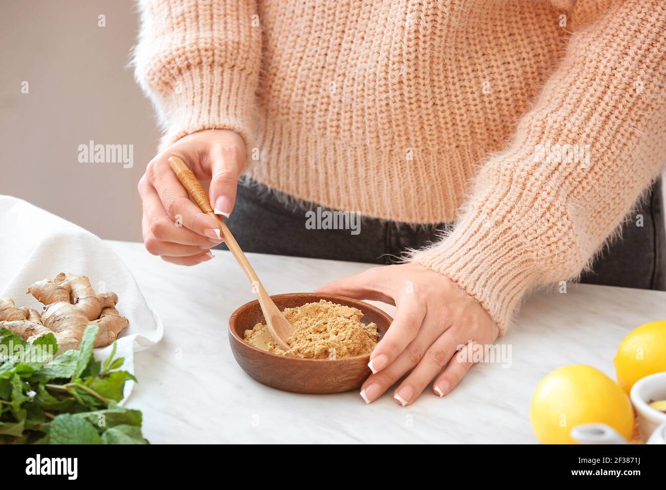 Woman with ginger powder on table in kitchen Stock Photo - Alamy