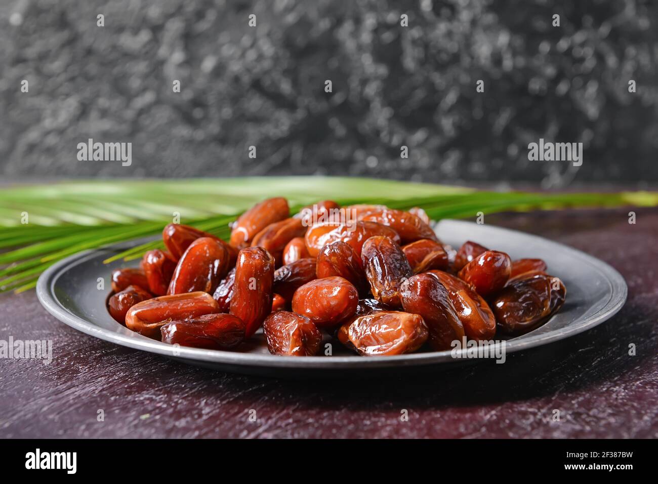 Plate with sweet dried dates on dark background Stock Photo - Alamy