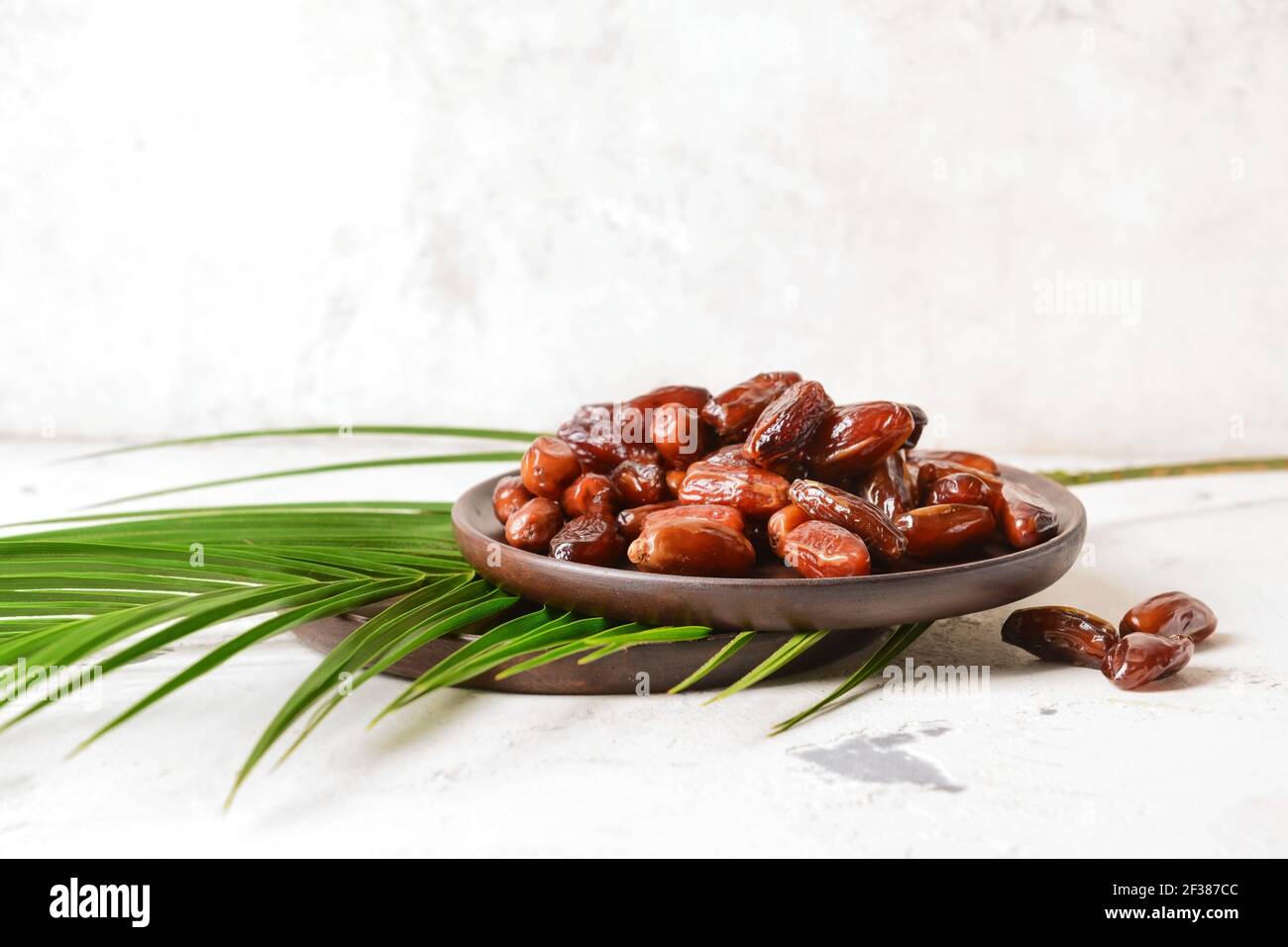 Plate with sweet dried dates on light background Stock Photo - Alamy