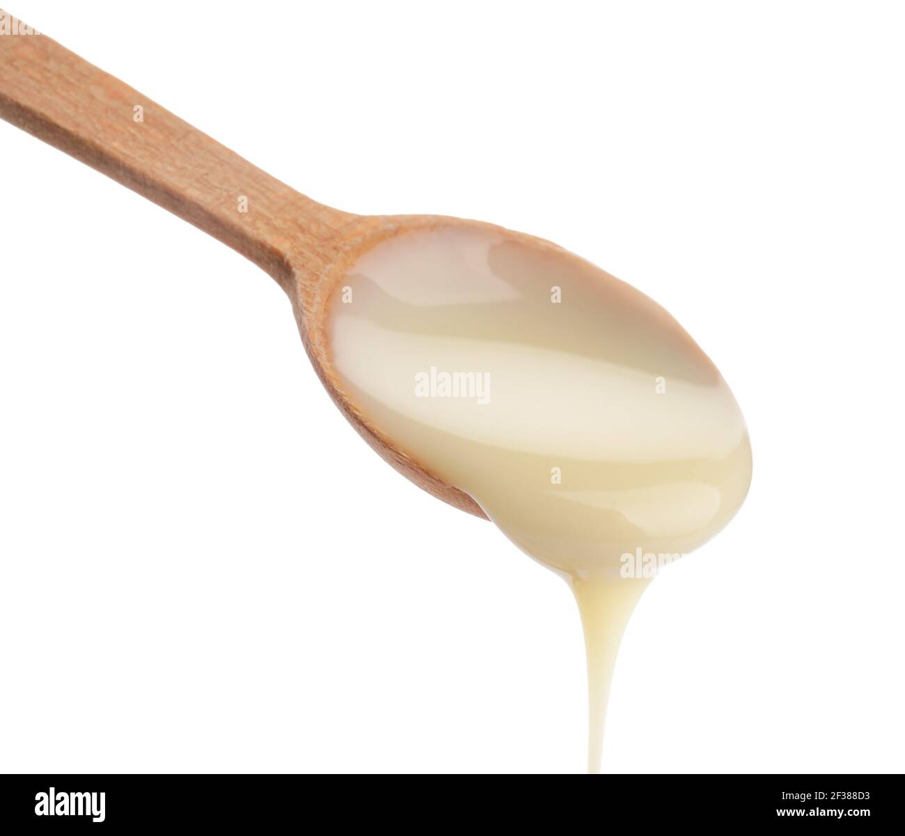 Wooden spoon of condensed milk on white background Stock Photo - Alamy