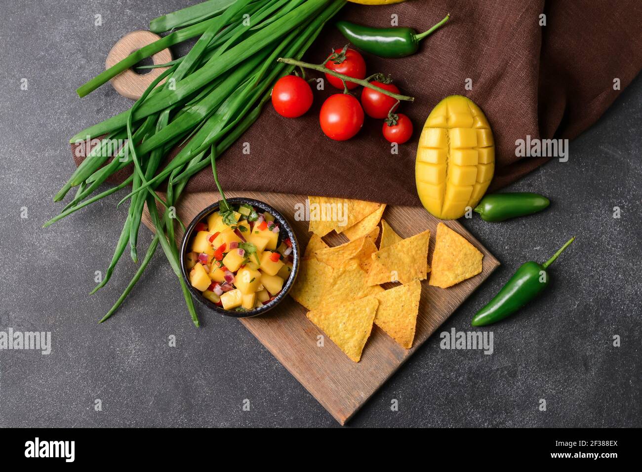 Composition with fresh mango salsa and nachos on dark background Stock ...