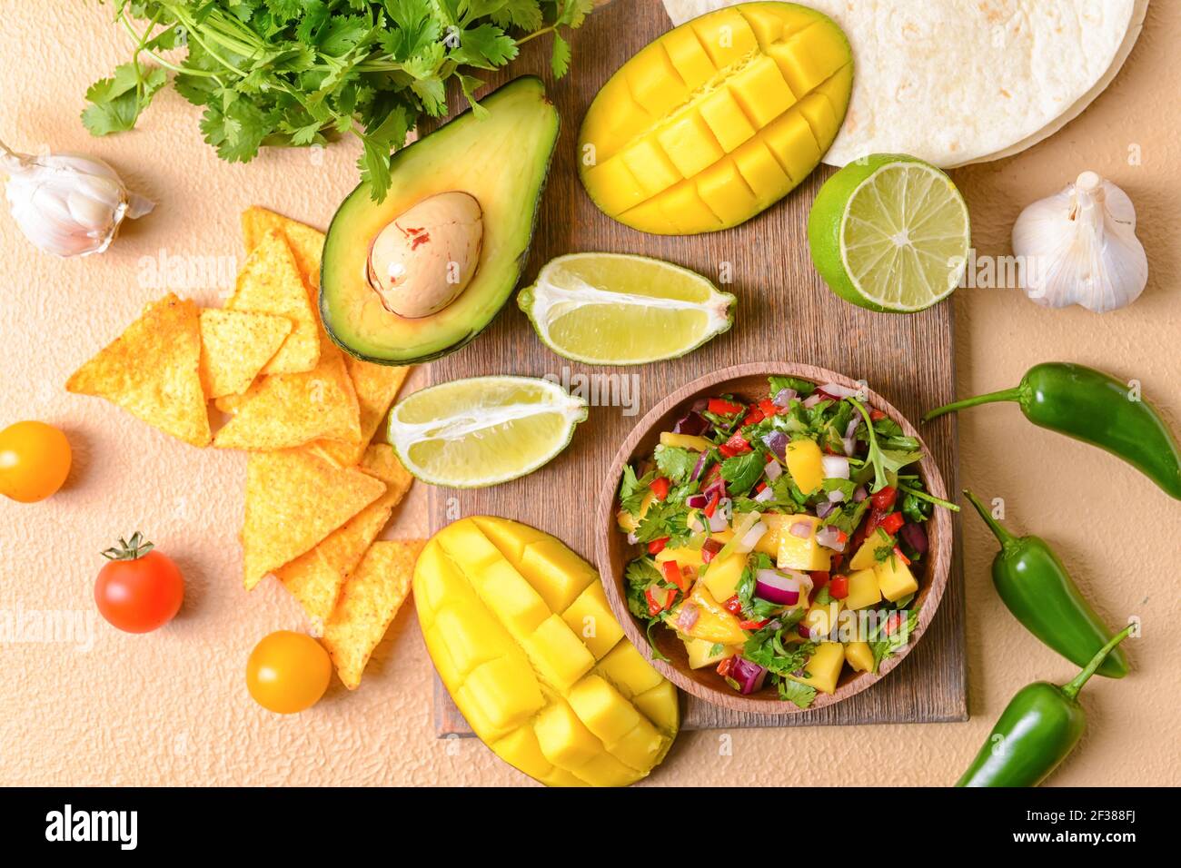 Composition with fresh mango salsa and nachos on color background Stock ...