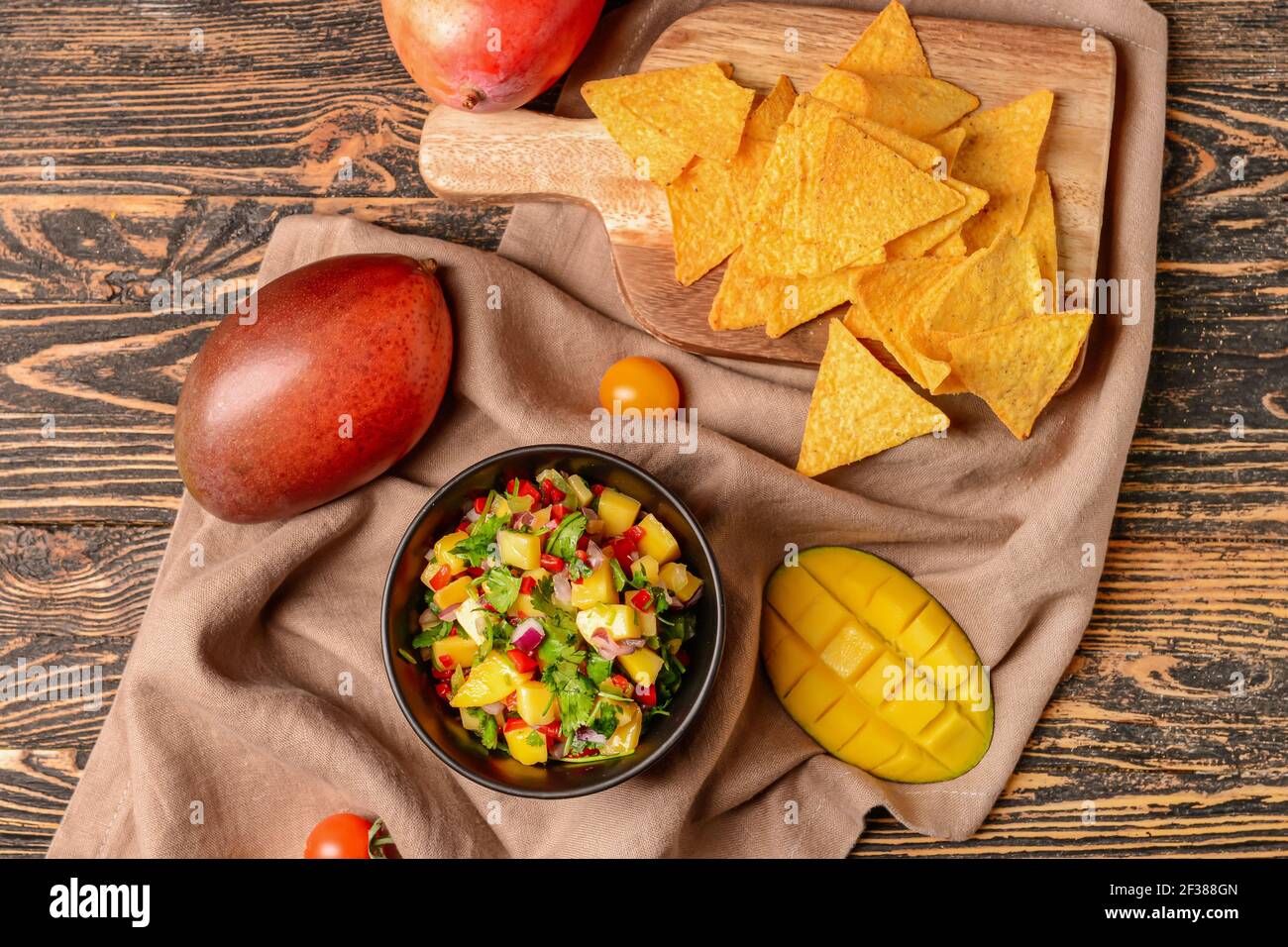 Bowl with fresh mango salsa and nachos on wooden background Stock Photo ...