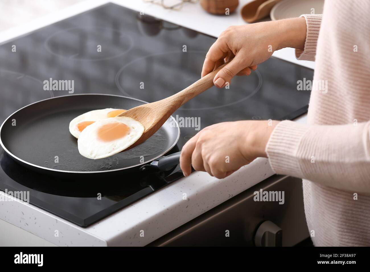 Woman cooking eggs in kitchen Stock Photo - Alamy