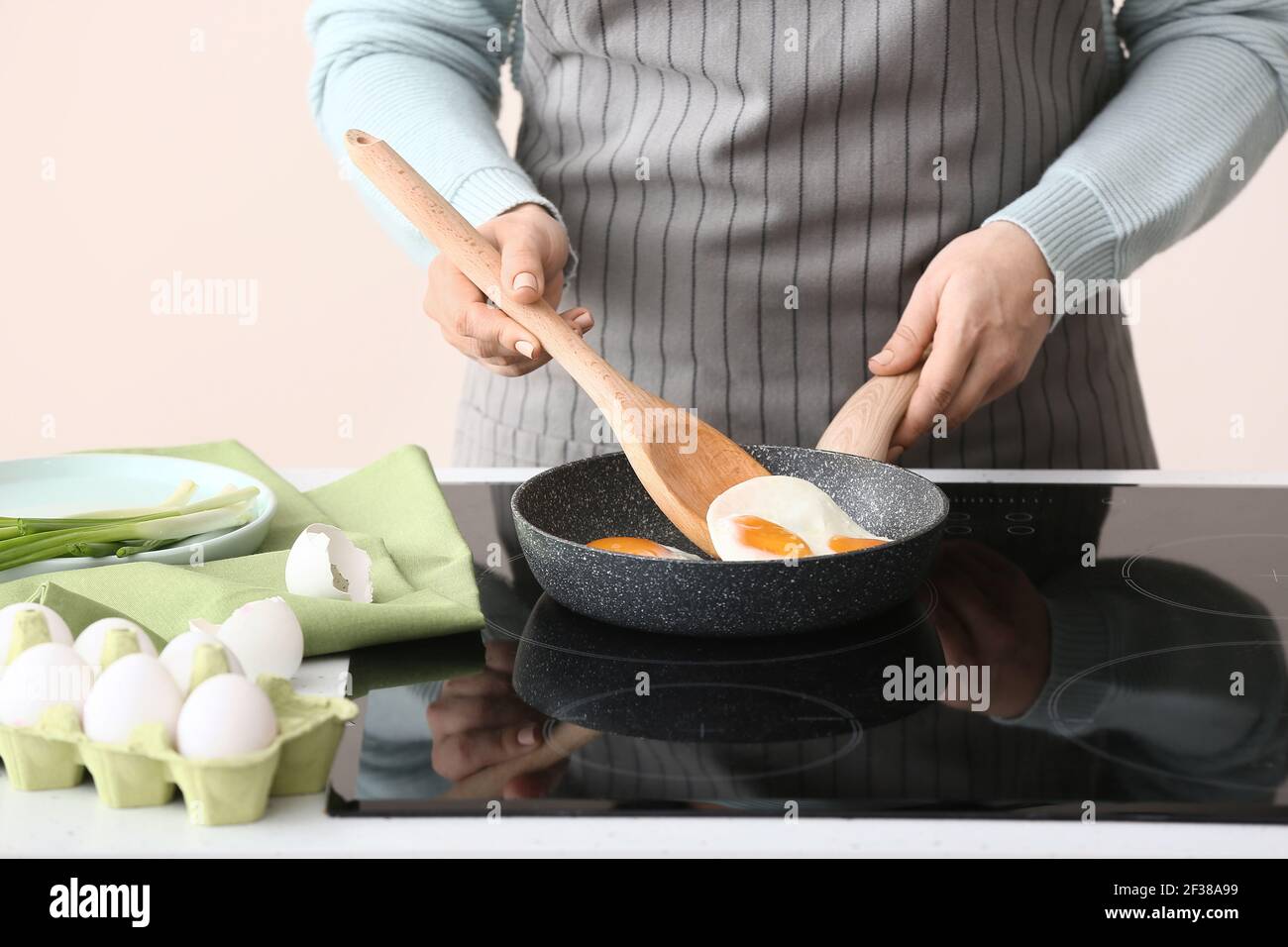 Woman cooking eggs in kitchen Stock Photo - Alamy