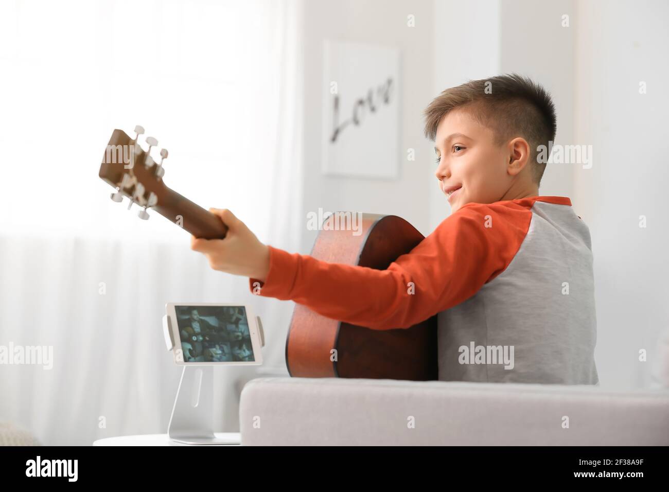 Little boy taking music lessons online at home Stock Photo - Alamy