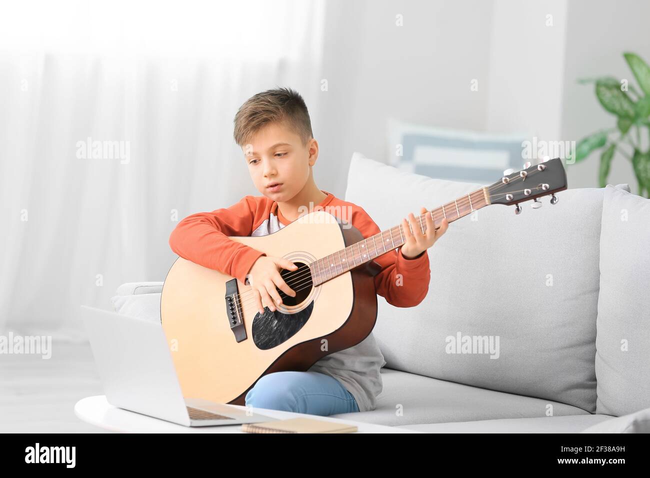 Little boy taking music lessons online at home Stock Photo - Alamy