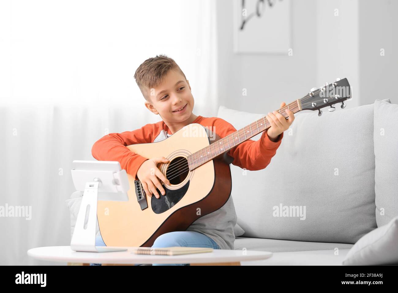Little boy taking music lessons online at home Stock Photo - Alamy