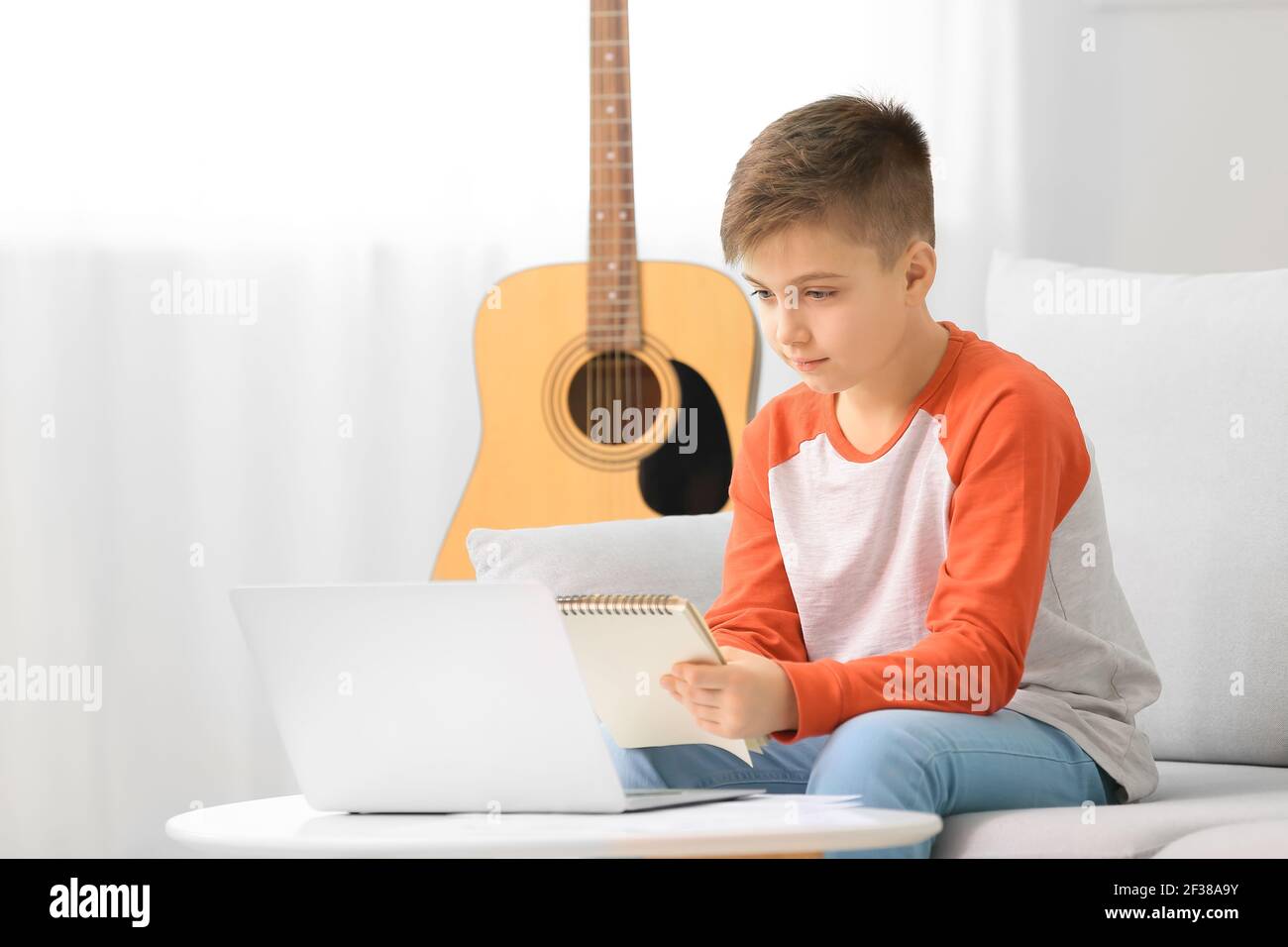 Little boy taking music lessons online at home Stock Photo - Alamy