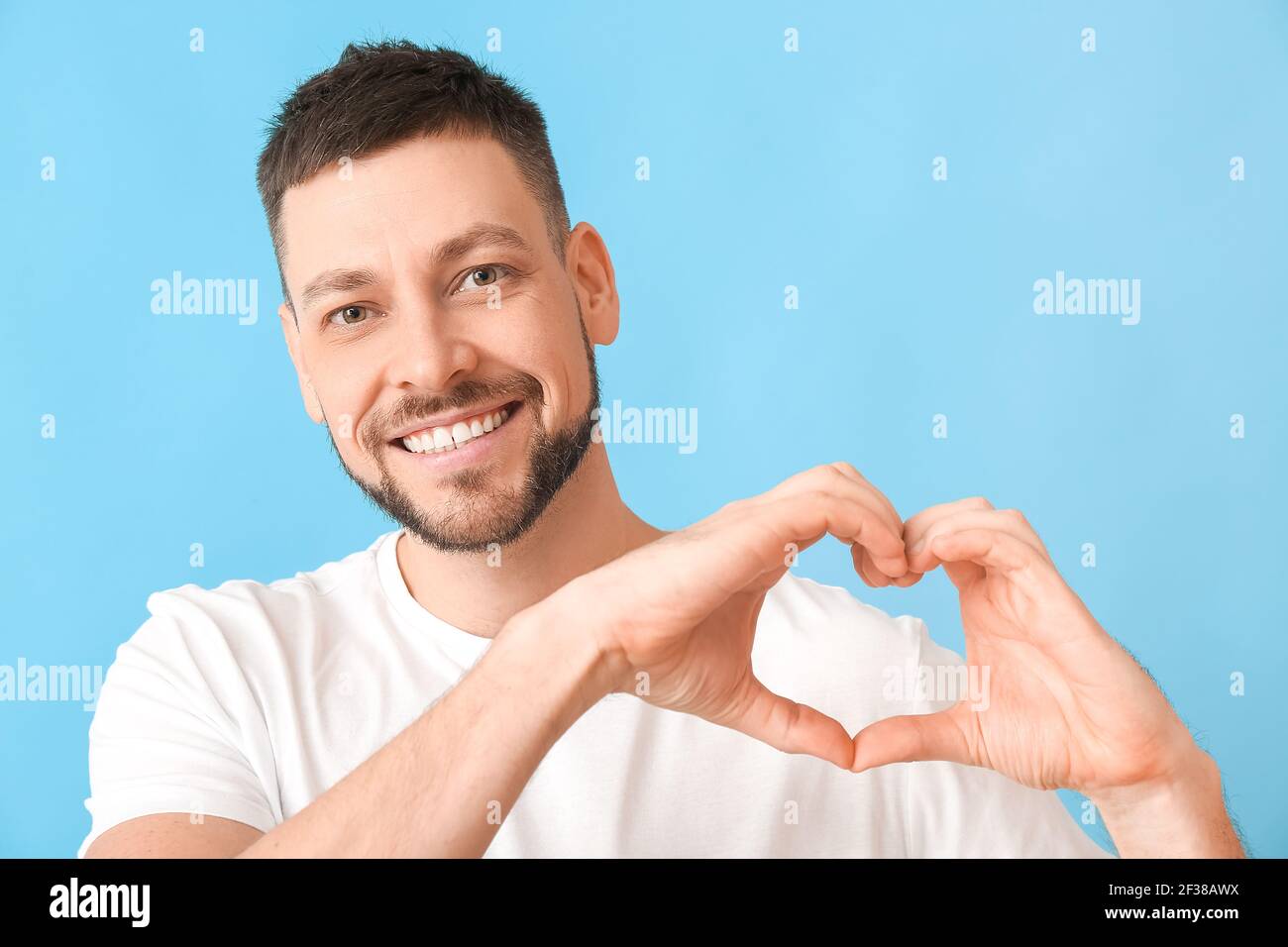 Man making heart with his hands on color background Stock Photo - Alamy