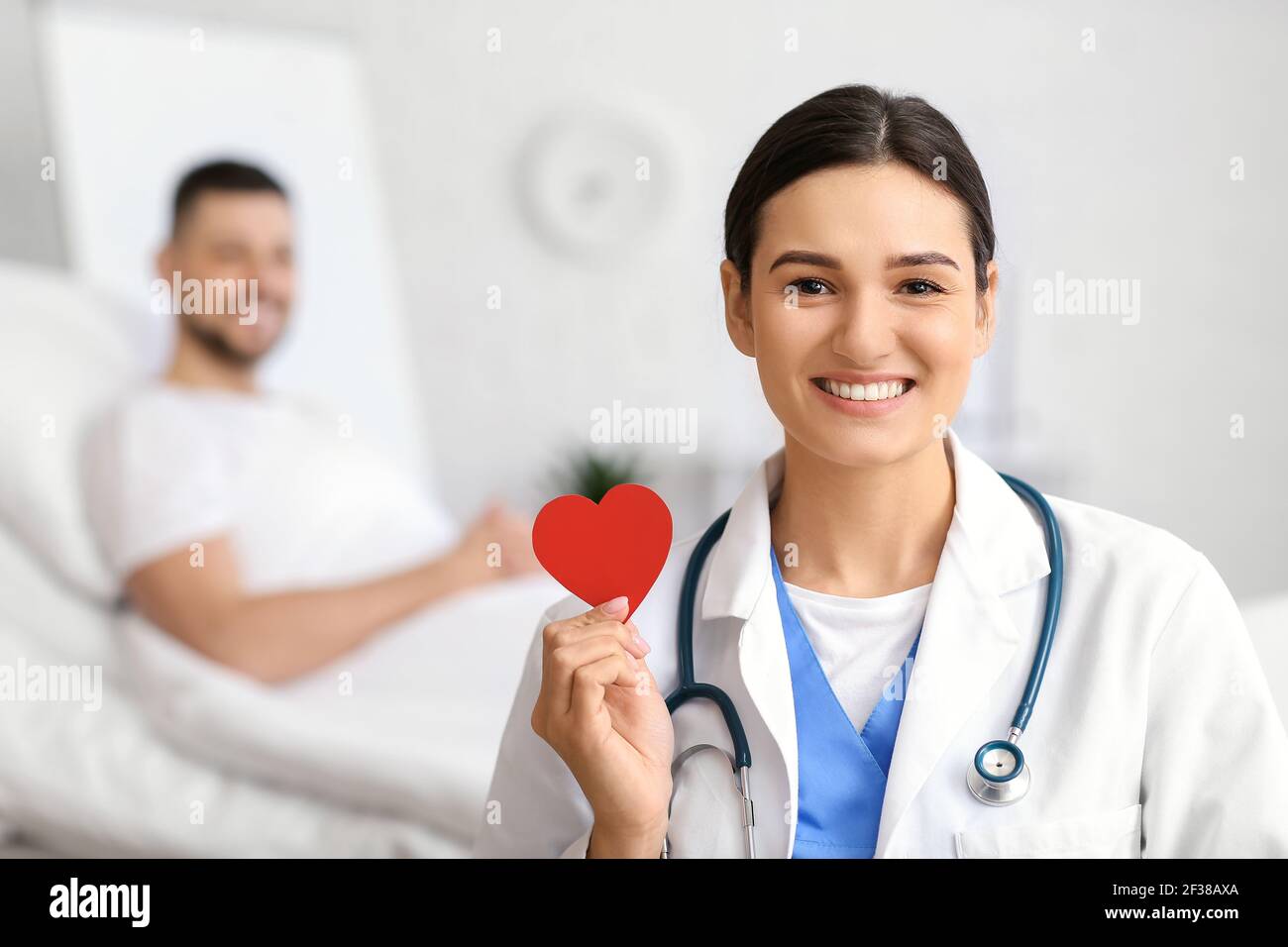 Cardiologist with red heart in clinic Stock Photo - Alamy