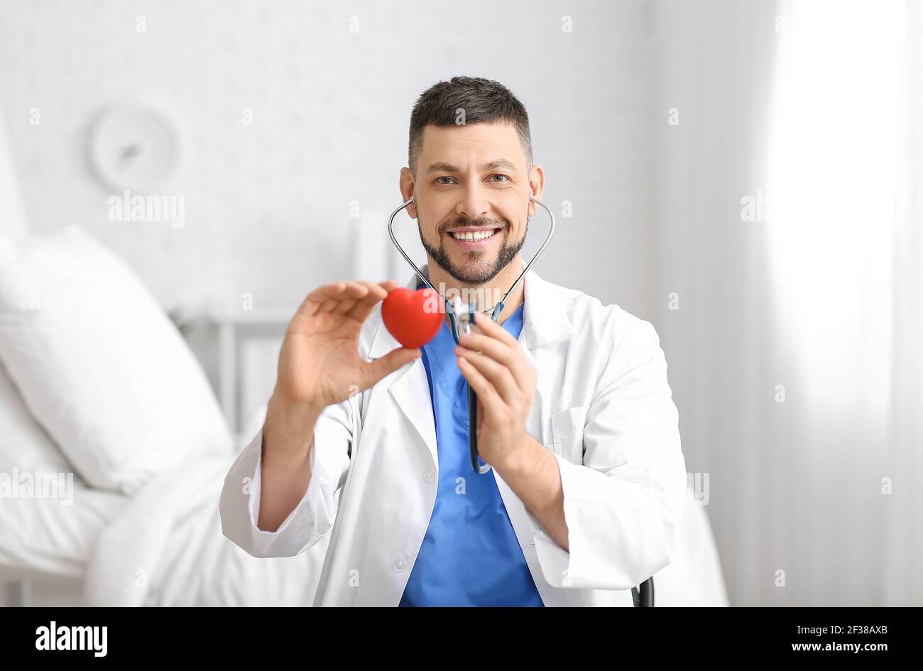 Cardiologist with red heart and stethoscope in clinic Stock Photo - Alamy