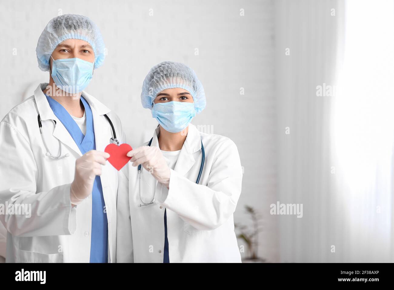 Cardiologists with red heart in clinic Stock Photo - Alamy