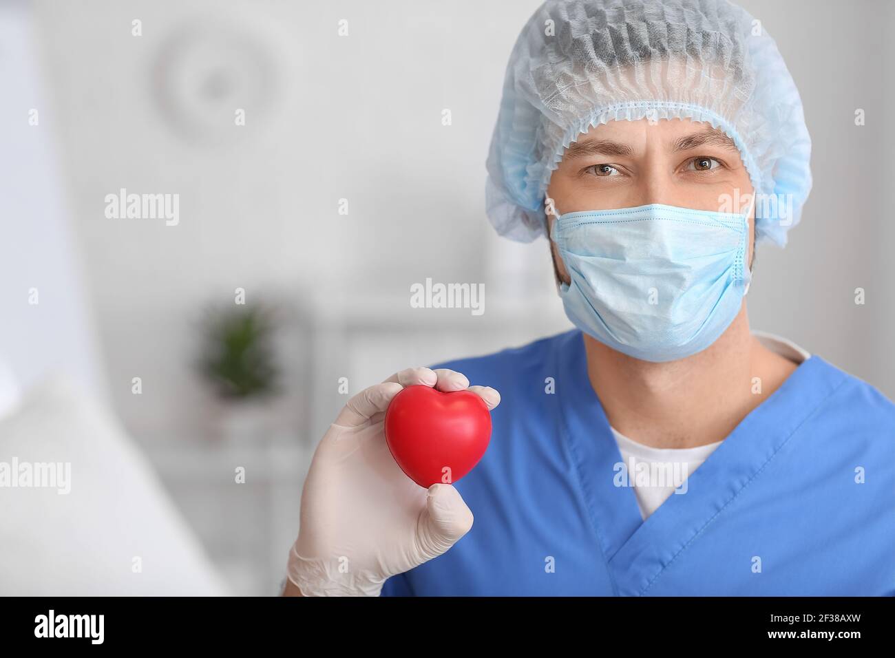 Cardiologist with red heart in clinic Stock Photo - Alamy