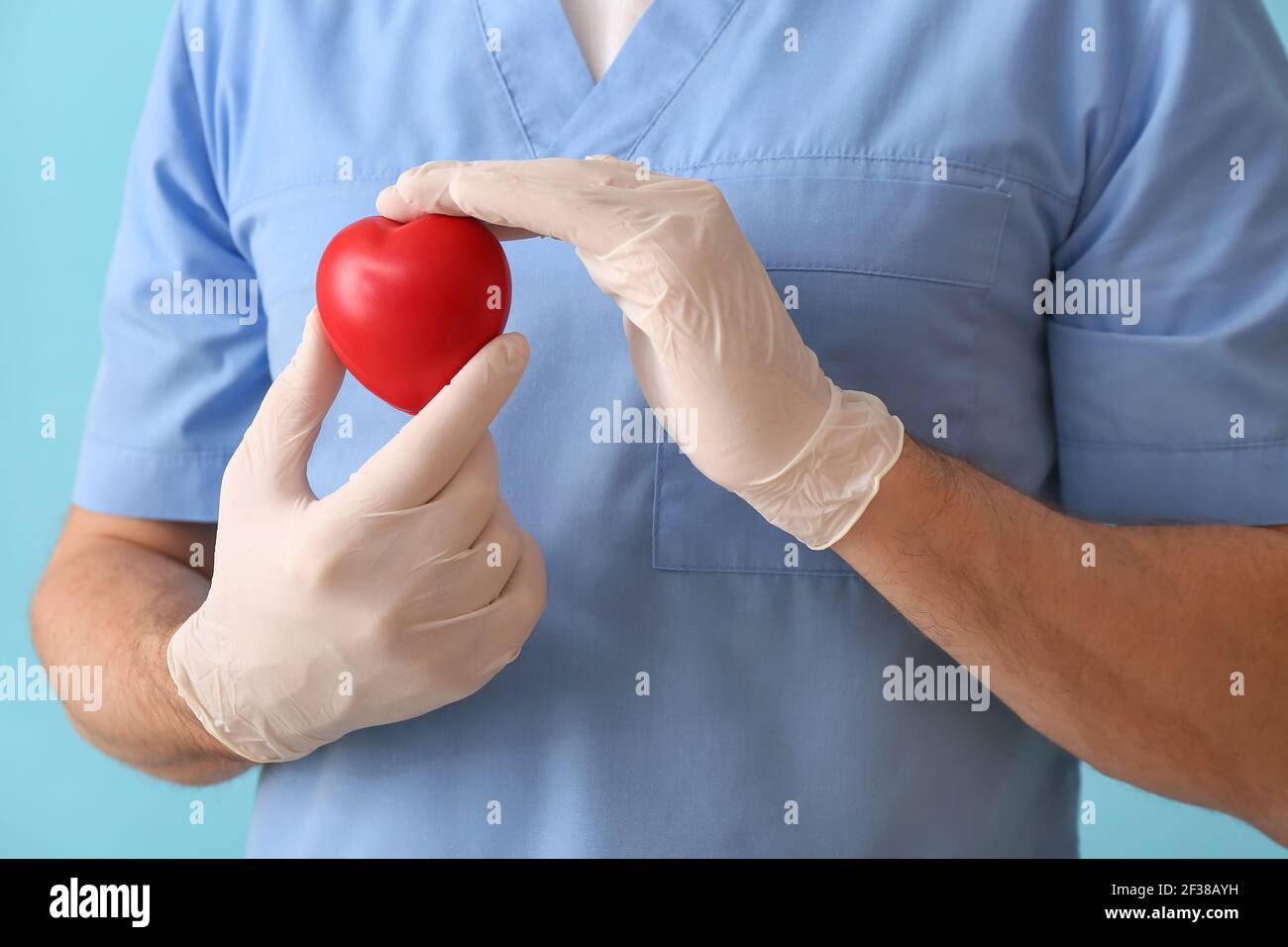 Cardiologist with red heart on color background, closeup Stock Photo ...