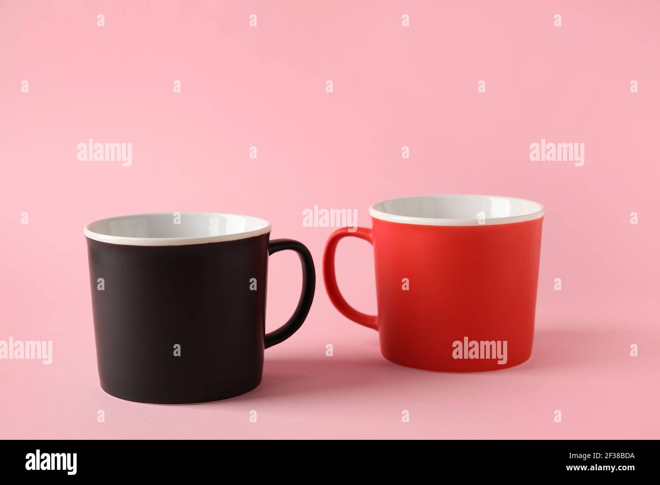 Empty cups on color background Stock Photo - Alamy