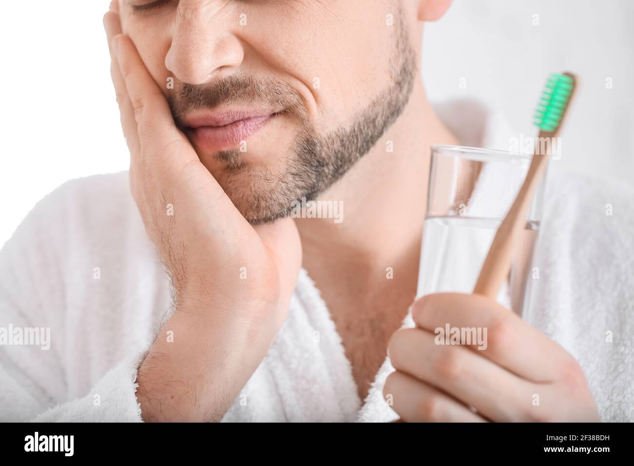Man suffering from pain while brushing teeth in morning, closeup Stock ...