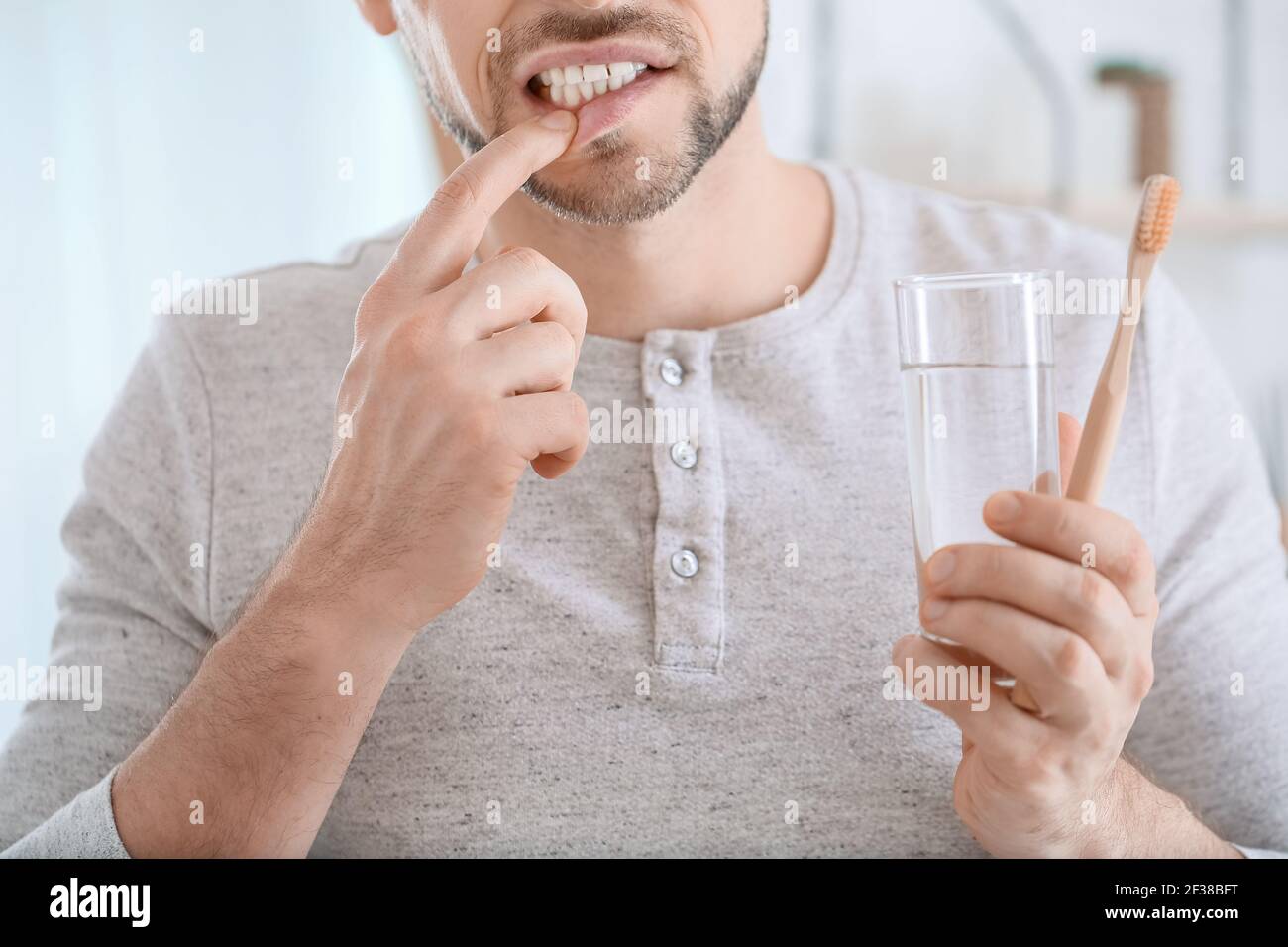 Man suffering from pain while brushing teeth in morning Stock Photo - Alamy