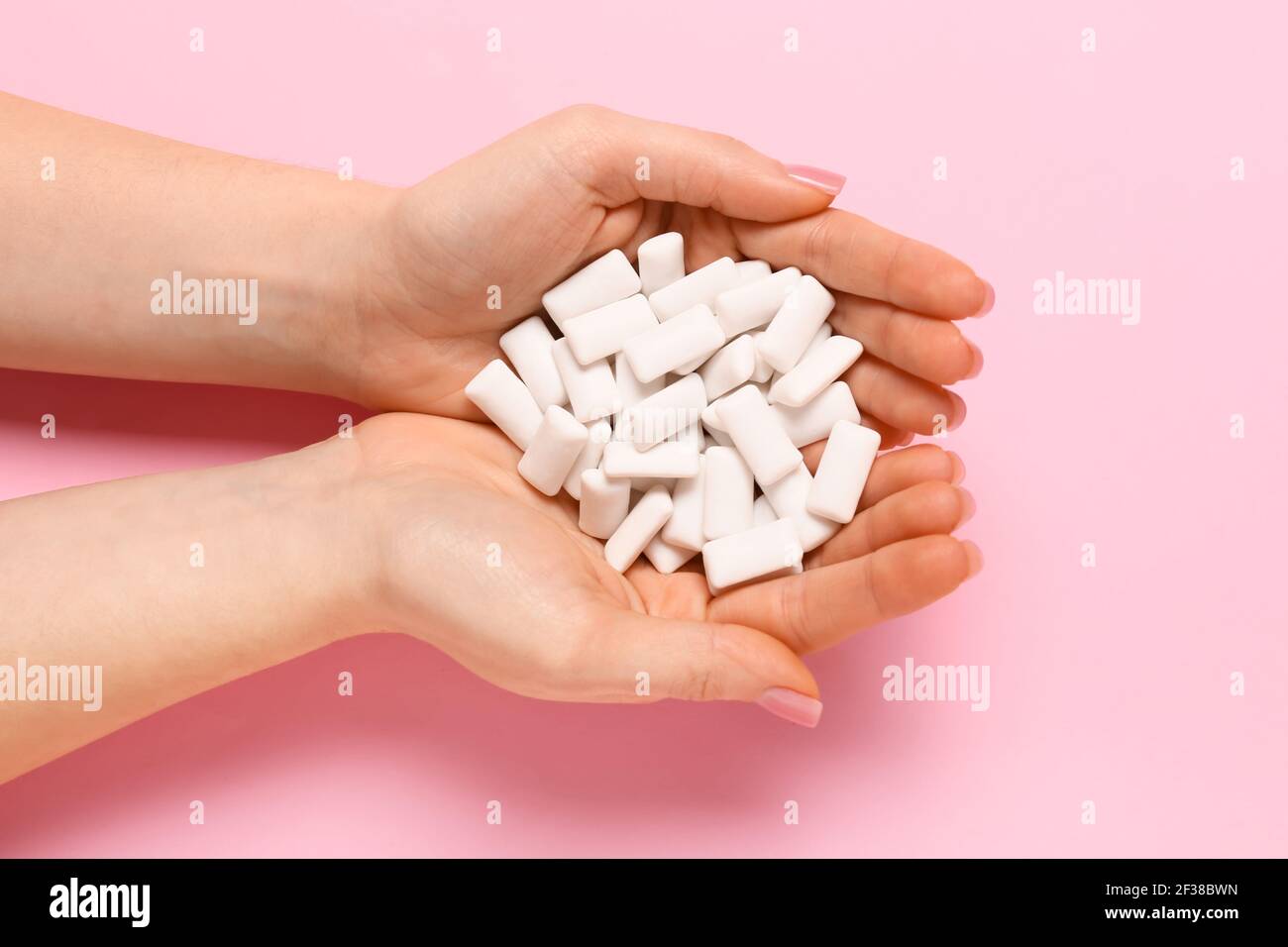 Female hands with tasty chewing gums on color background Stock Photo ...
