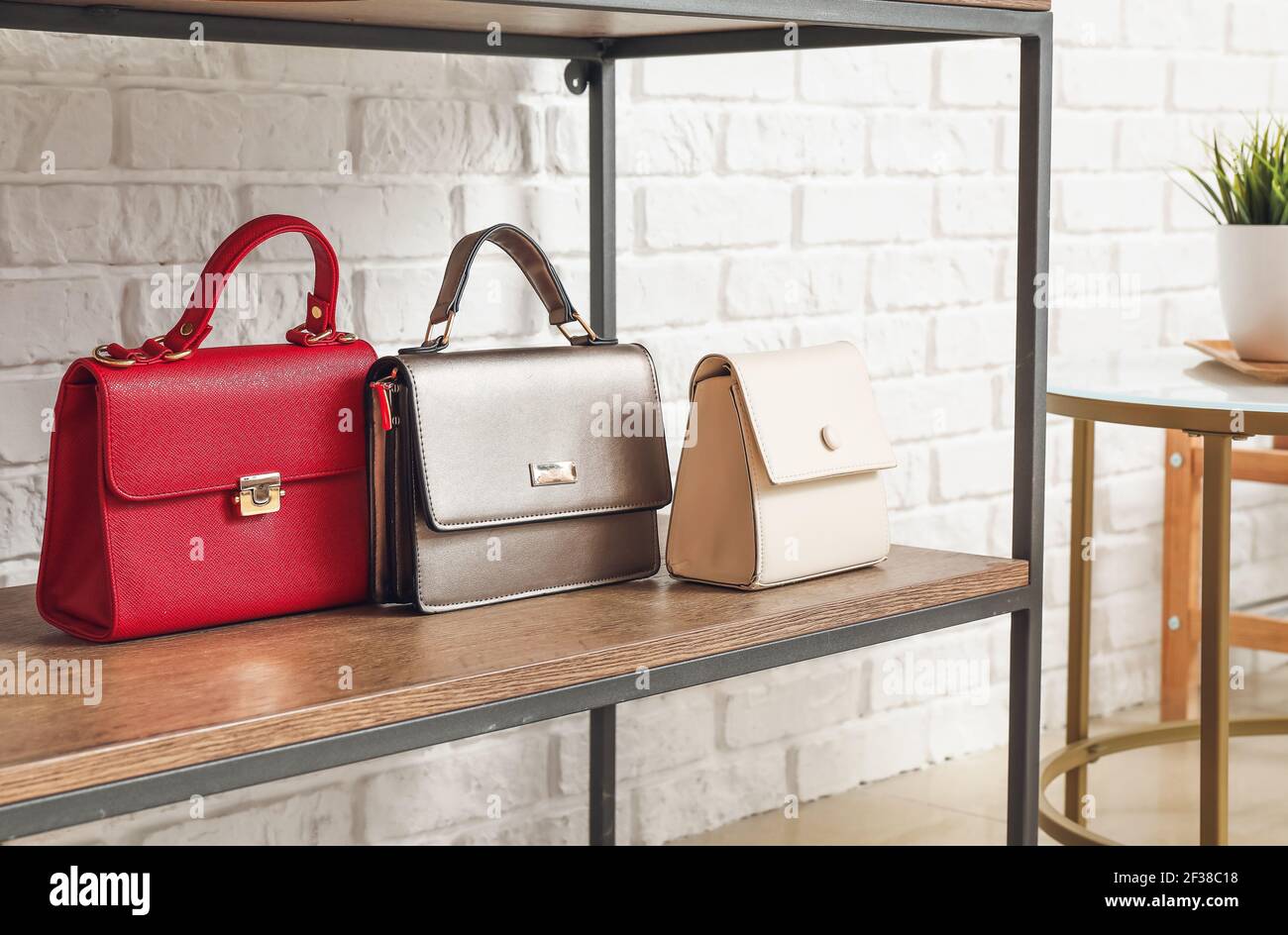 Stylish female bags on shelf in modern hall Stock Photo - Alamy