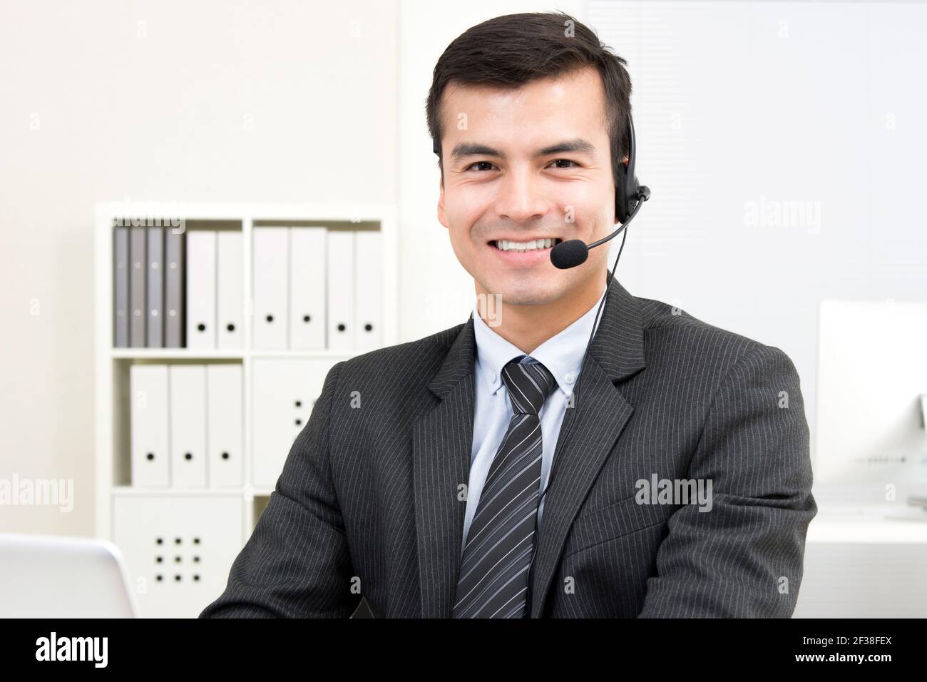 Smiling handsome businessman wearing microphone headset - telemarketing ...